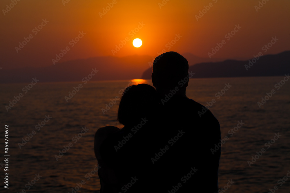 Attractive young man and woman standing against sunset sky. Romantic ...