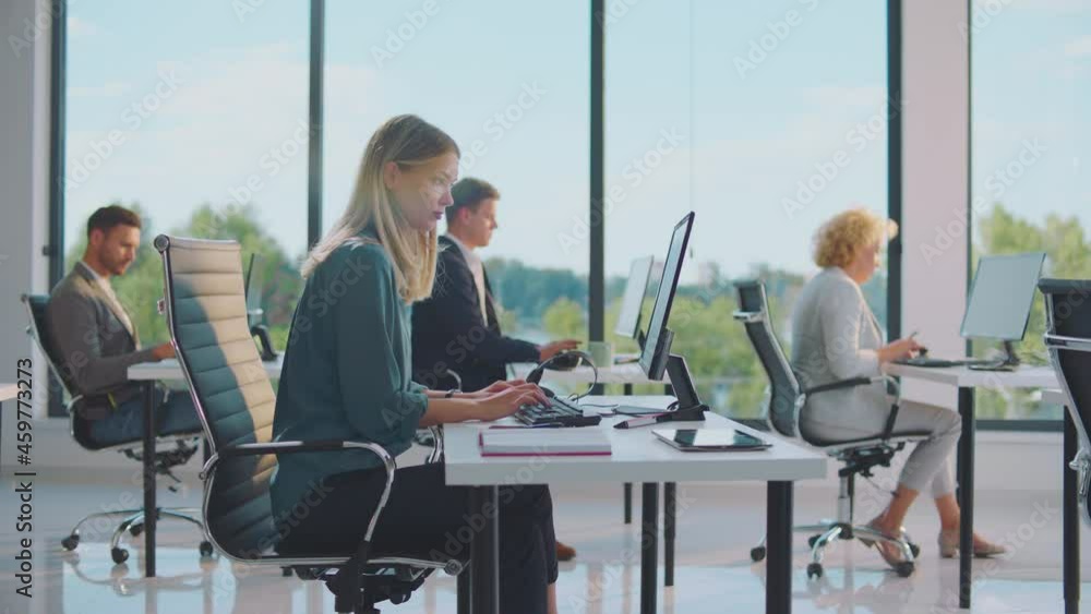 People working on computer in room with large windows. Speaking ...