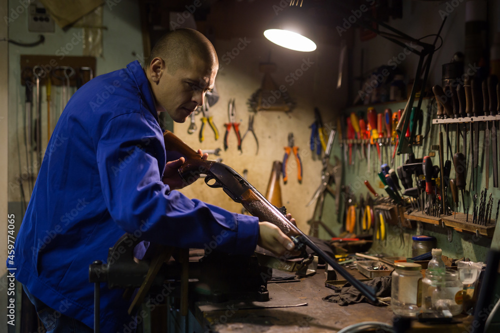Professional gunsmith performing checkout of single-barrelled shotgun ...
