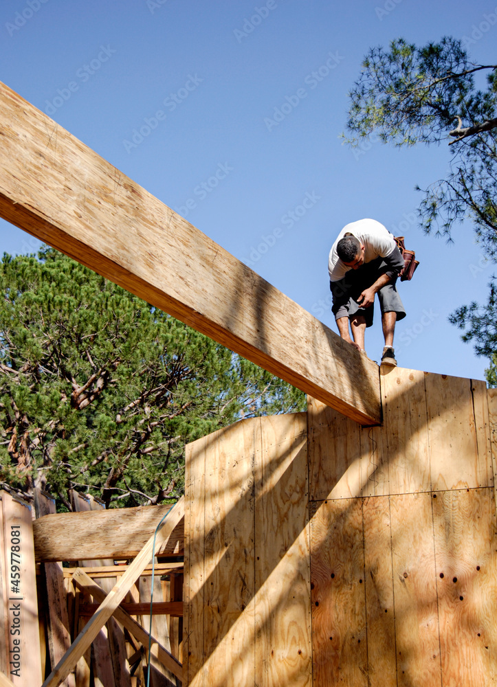 Frame carpenter setting a large ridge beam on top of a wall Stock Photo ...