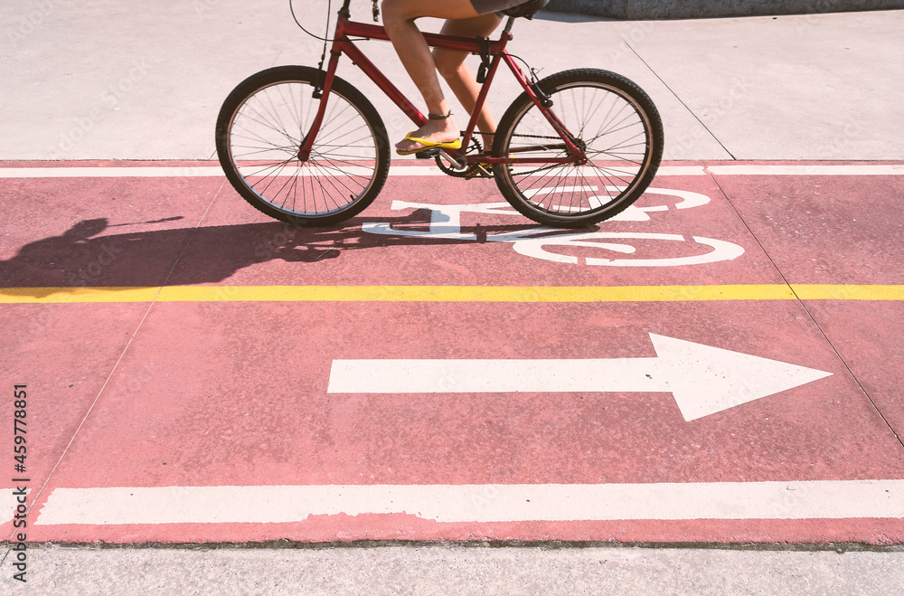 Partial view of the tanned legs of a woman wearing yellow slippers and ...