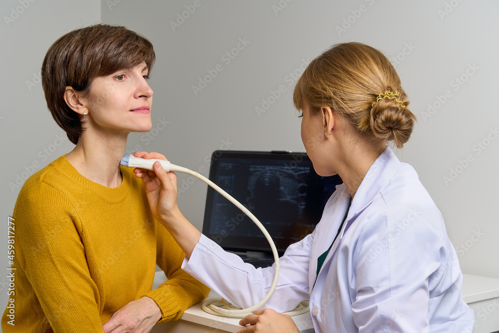 Faceless medical worker conducting thorough scan of cervical veins and ...