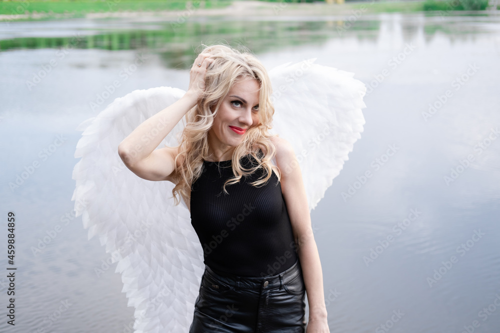 fallen angel. girl in black with white angel wings. Stock Photo | Adobe ...