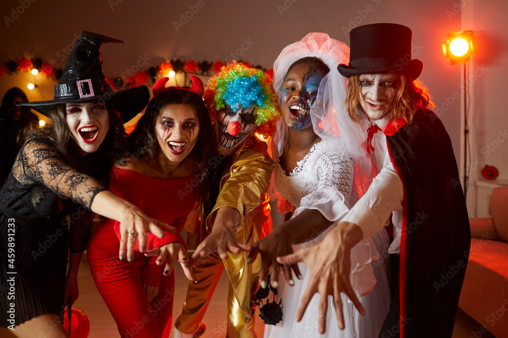 Group of adult friends having fun at dark carnival party. Happy people ...