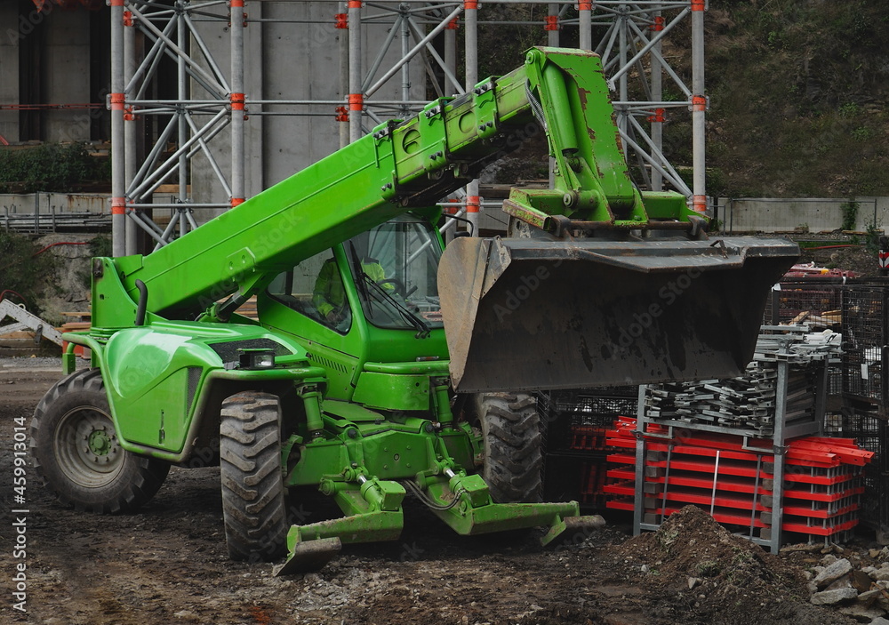 excavator, construction car manita with a bucket at work, green color ...
