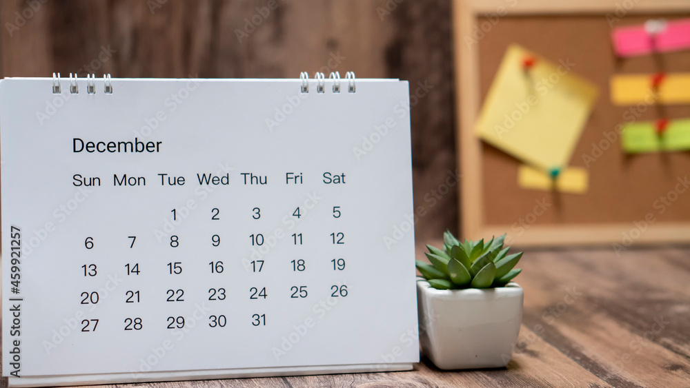 Desktop calendar and cactus placed on student wooden desk at home ...