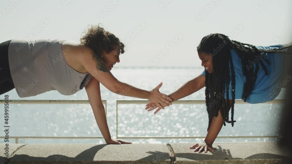 Fat women standing in plank position and giving each other five. Side ...