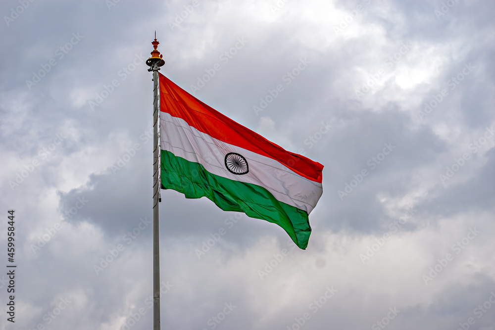 Indian National Flag , flying high in the sky on a cloudy background ...