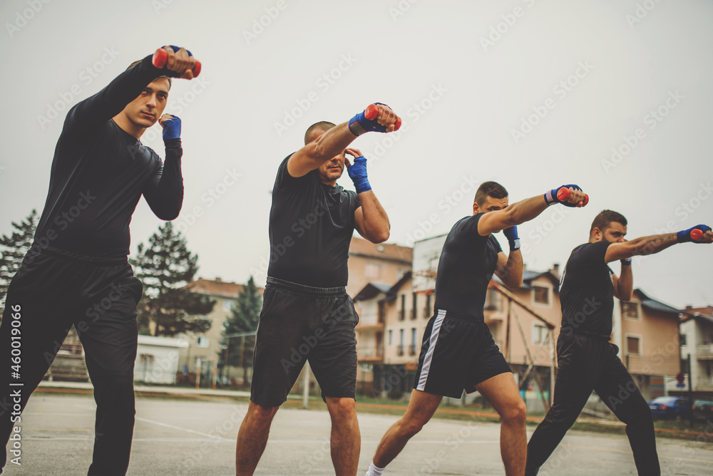 Professional boxers doing boxing exercises outdoor with their trainer ...