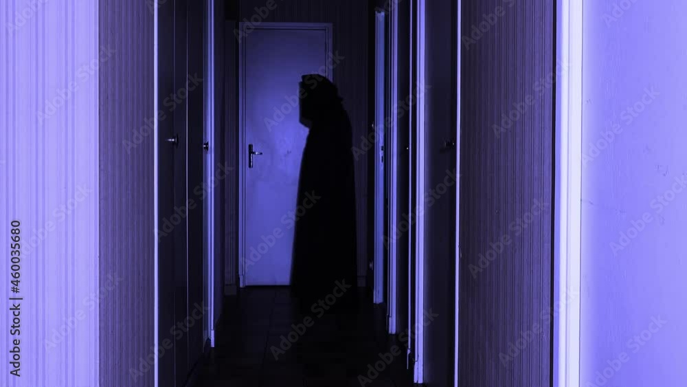 A dark blurred figure in tappears from the doorway at the end of the ...