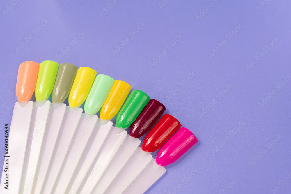 Multiсolor nail tips on a purple background. examples of manicure for ...
