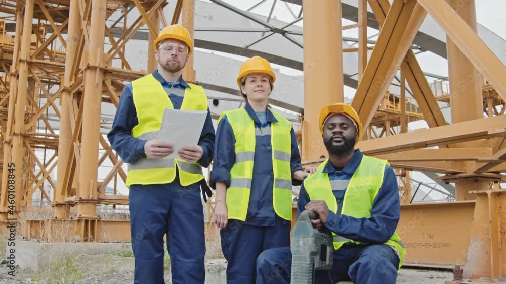Tracking portrait shot of male and female construction workers in ...
