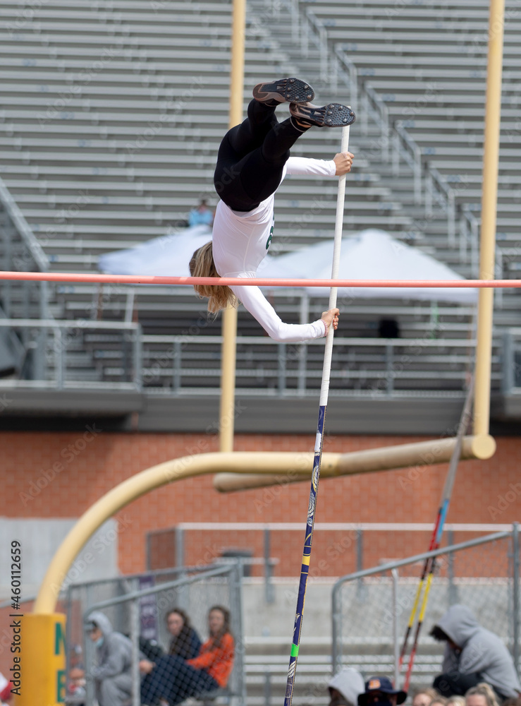 High School girls competing in pole vault at a track and field meet ...