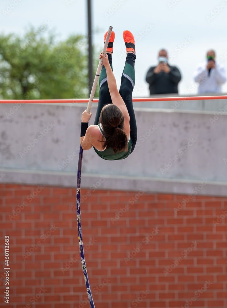 High School girls competing in pole vault at a track and field meet ...