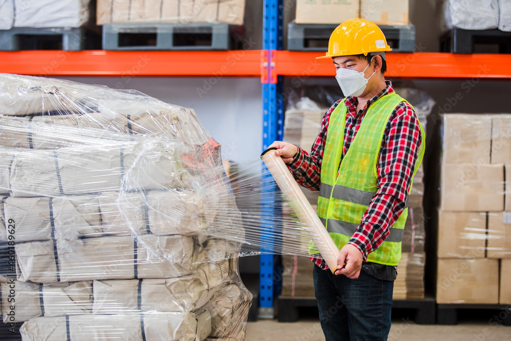 Warehouse Staff wearing a protective face mask and safety suite ...