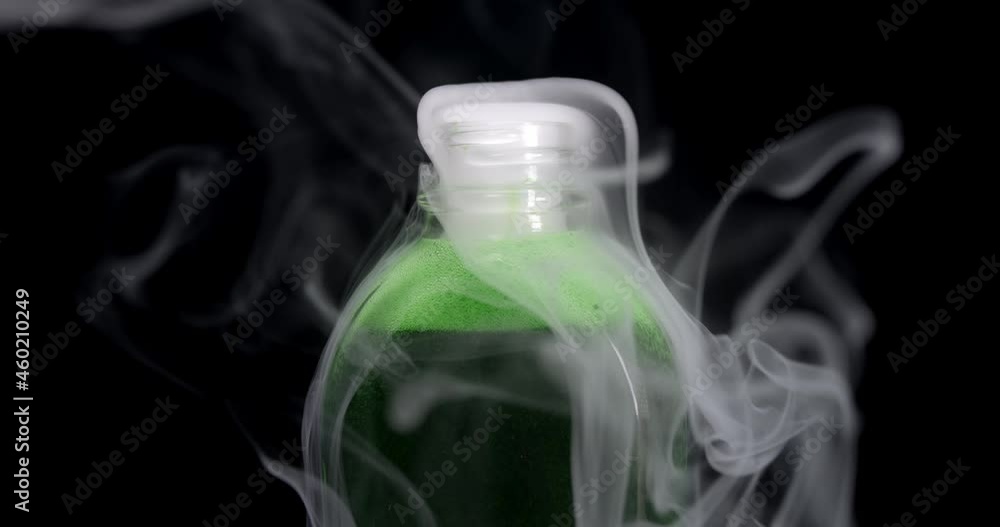 Bottle filled with toxic green liquid bubbling up and smoking. Concept ...