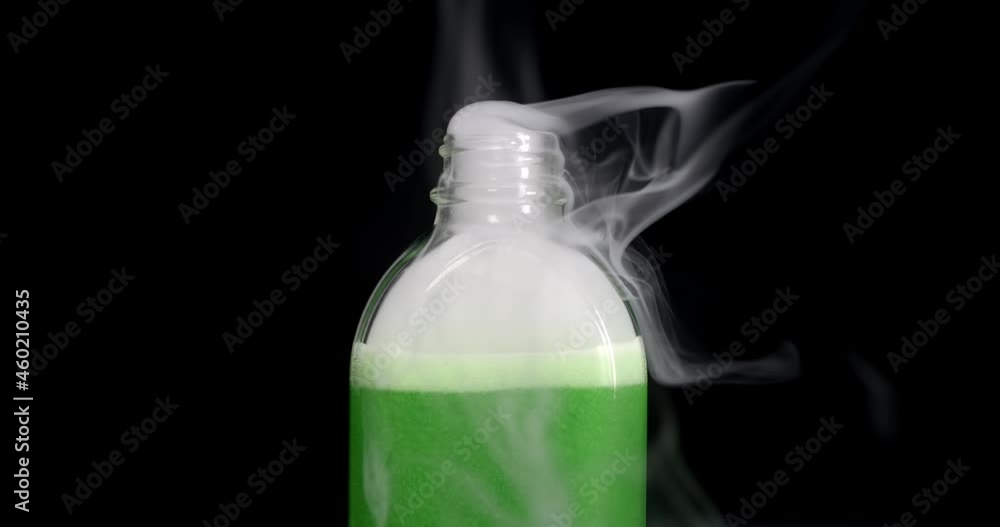 Bottle filled with toxic green liquid bubbling up and smoking. Concept ...