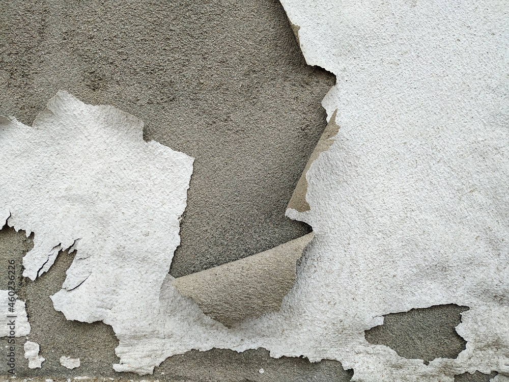The wall of theold concrete house, painted in white. Peeling, falling ...