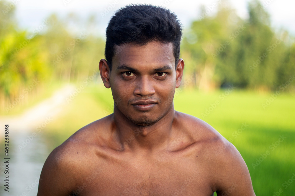 A poor boy showing his body in a rural environment. his muscle is high ...