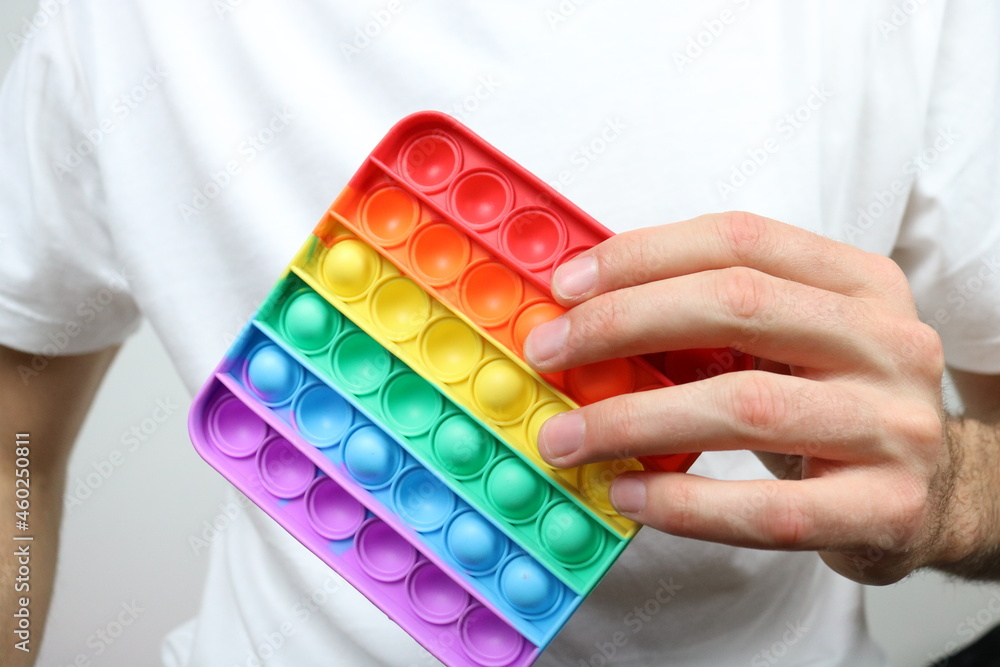 Hand holding pop it, bubble popping fidget toy Stock Photo | Adobe Stock
