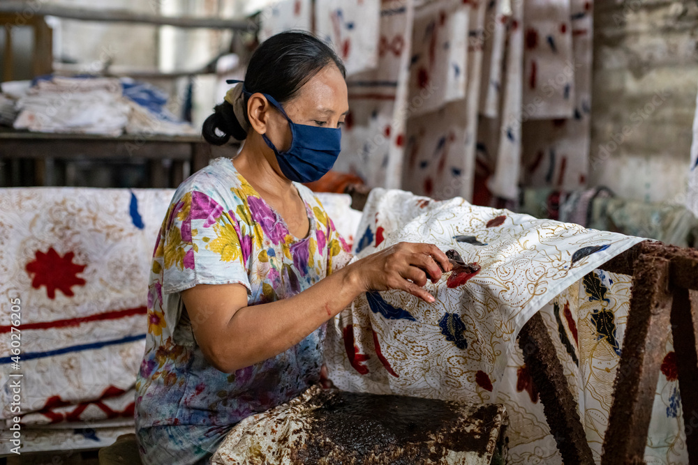 A batik craftsman is making batik. Batik is one of Indonesia's cultural ...