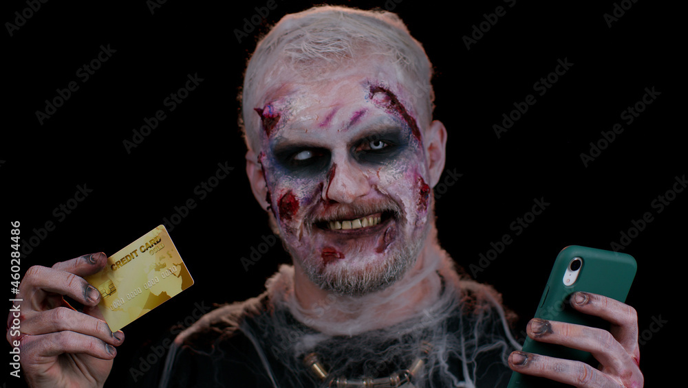 Sinister man with horrible scary Halloween zombie make-up using credit ...