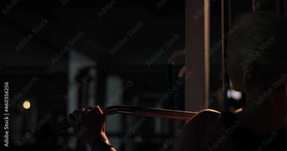 Super close-up, backlit rear view of a determined fitness lady with ...