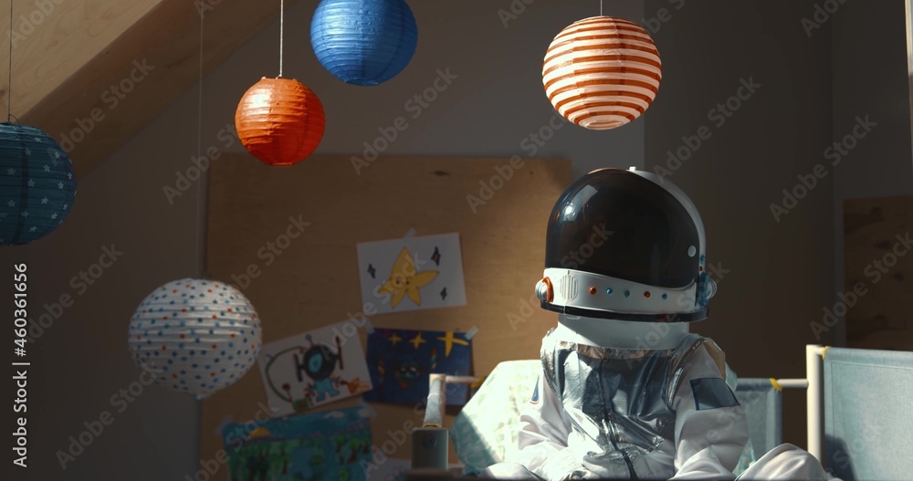 Dreaming to become astronaut. Little child sleeping in his space-themed ...