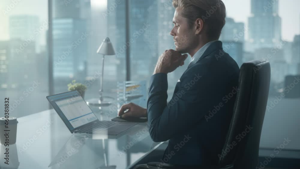 Confident Businessman in a Suit Sitting at a Desk in Modern Office ...
