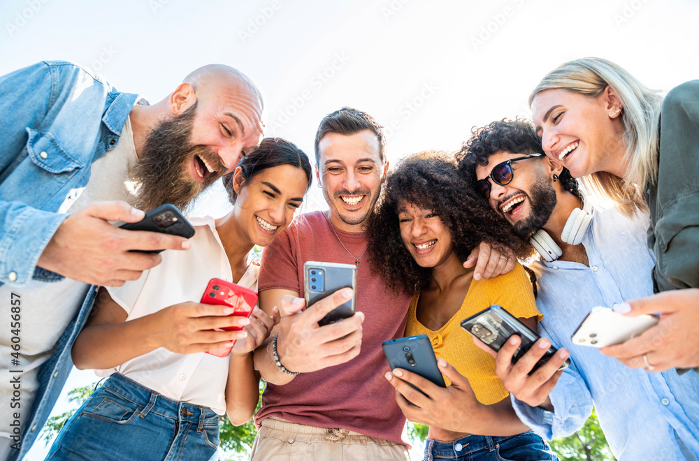 Foto de Diverse teenage students using digital smart mobile phones on ...