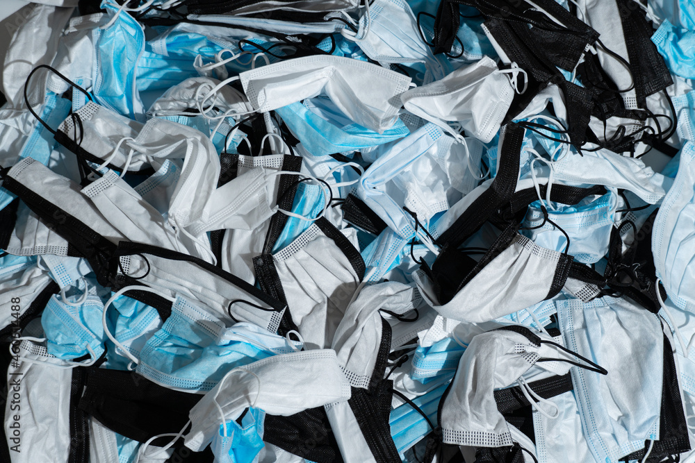 Medical masks on the table. Pile of used personal protective equipment ...