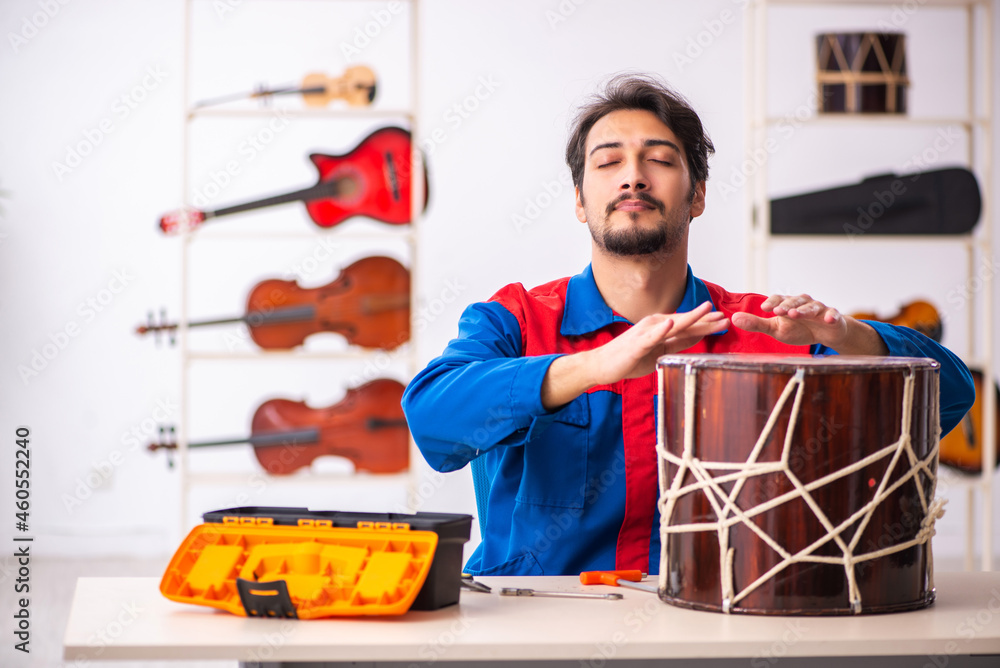Young male repairman repairing musical instruments at workplace Stock ...