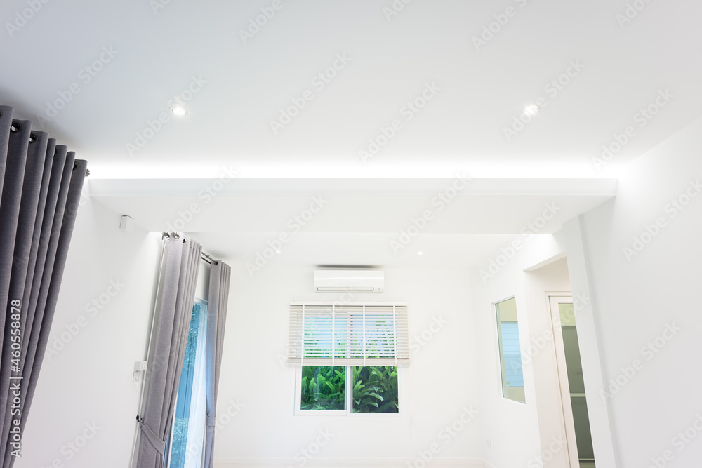 LED strip or ribbon light suspended on ceiling in empty living room ...
