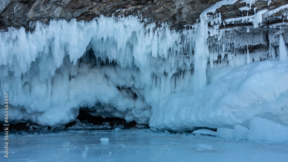 Rows of stalactite icicles, similar to lace frills, hang from the base ...