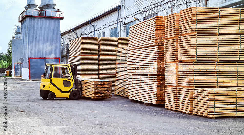 Forklift loads lumber into stacks at the finished product warehouse ...