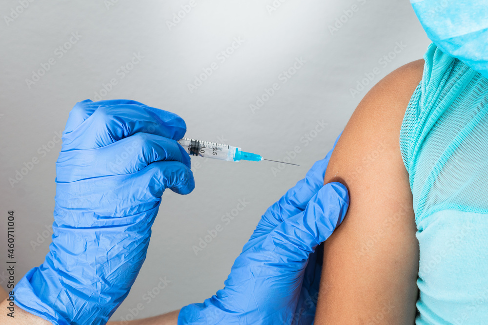 children's nurse about to administer the injection into the arm of a ...