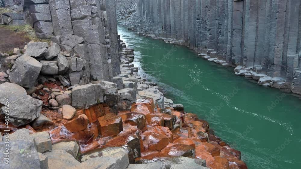Vidéo Stock Reveal of orange-grey basalt canyon with a green massive ...