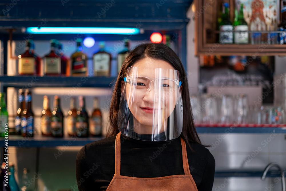 Asian adult owner gen z young woman is wearing protective face shield ...