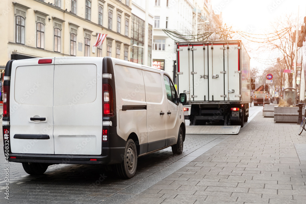 Small white van and mid size cargo truck parked for unloading at ...