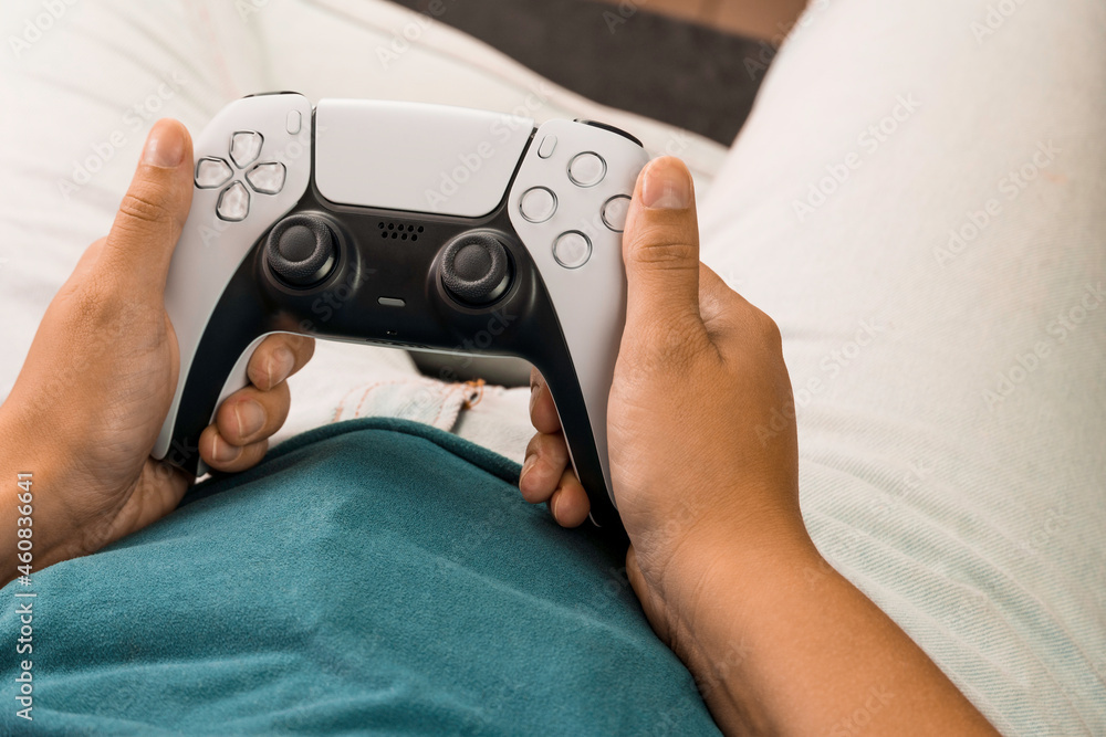 Girl holding a next generation white game controller while playing the ...