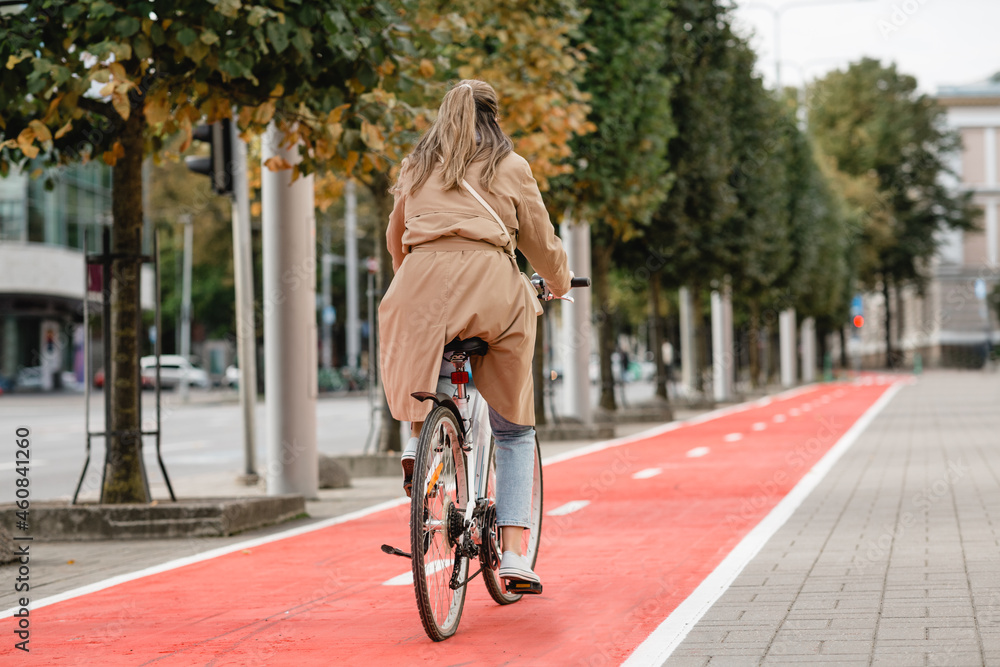 traffic, city transport and people concept - woman riding bicycle along ...