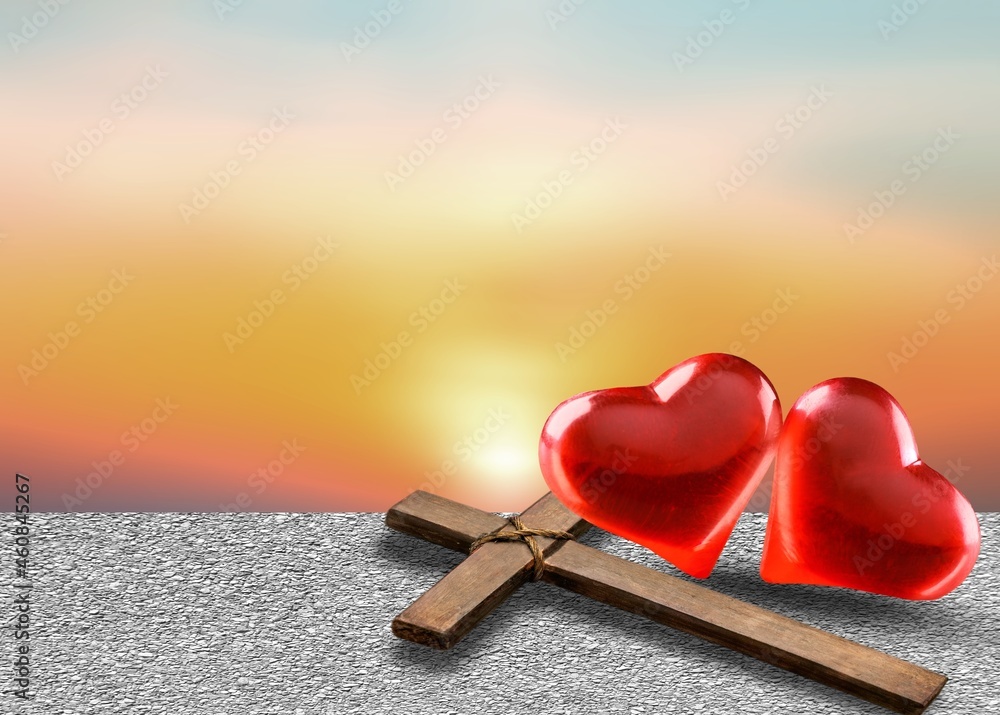 Red heart with a wooden Christian cross on floor in the morning light ...