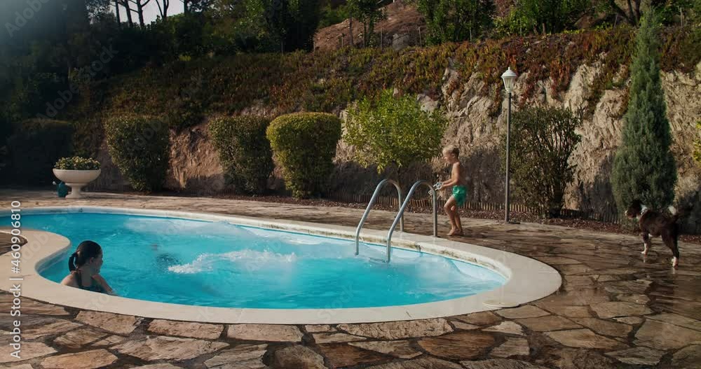 Young men is running and diving into the swimming pool, he's son and ...