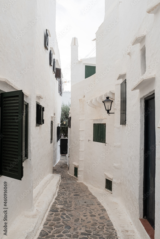 Narrow street corner on a cobble stone street on an old white village ...