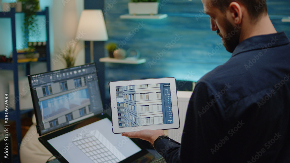 Architect holding digital tablet with building model for construction ...