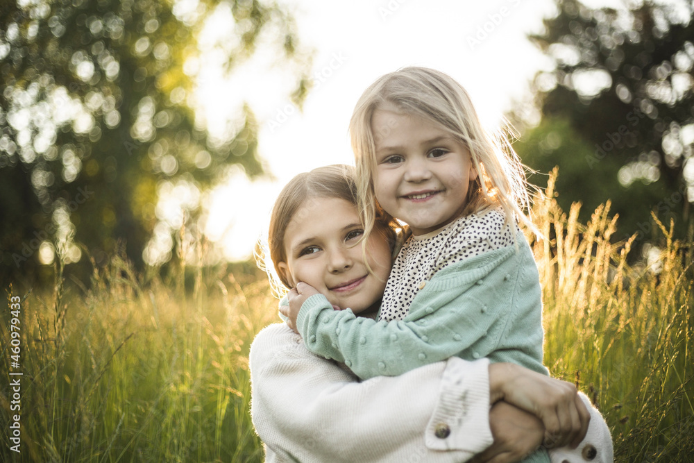 Portrait of mother, father and two daughters standing by car at ...