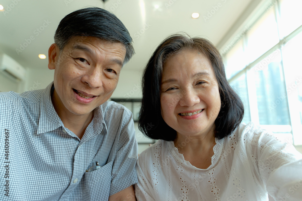 Happy elderly Asian couple doing facetime video calling with a ...