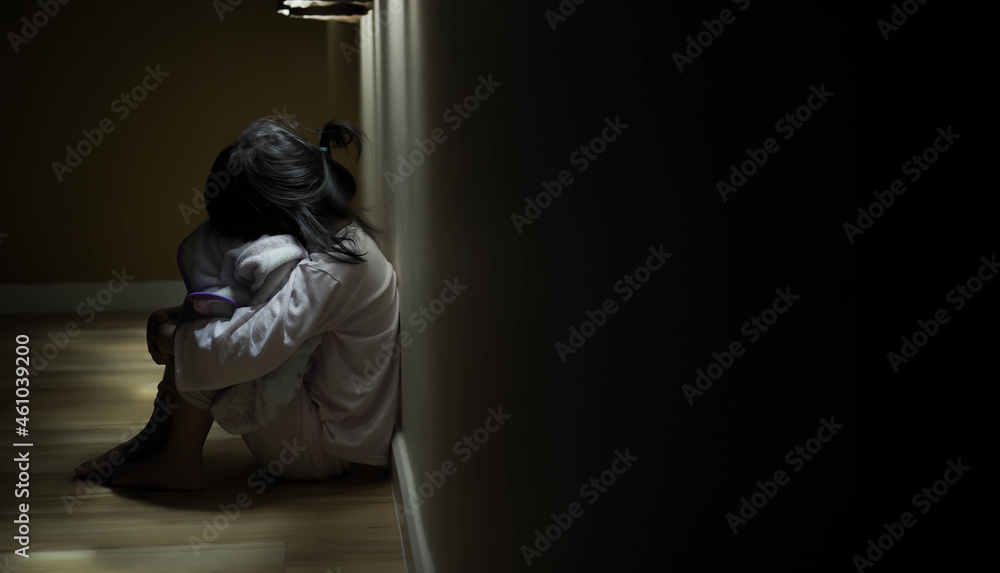 Squat single child sit near window, sad lonely in dark night indoor ...