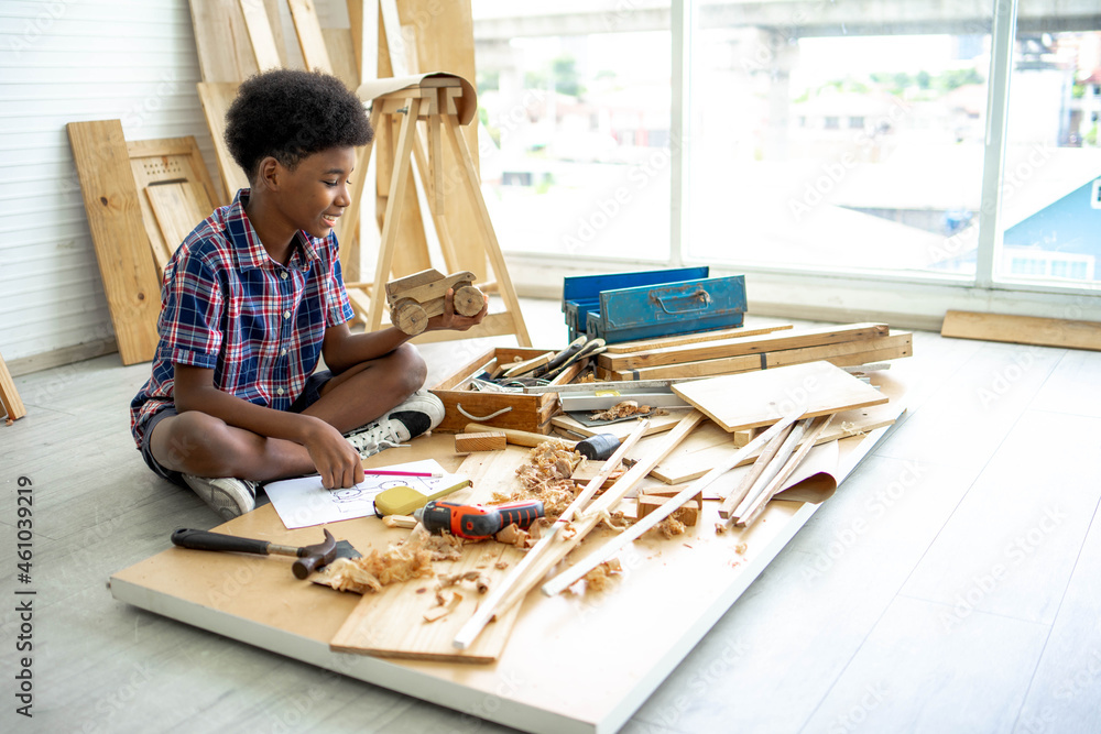 A young african boy carpenter happy working with wood handyman creating ...