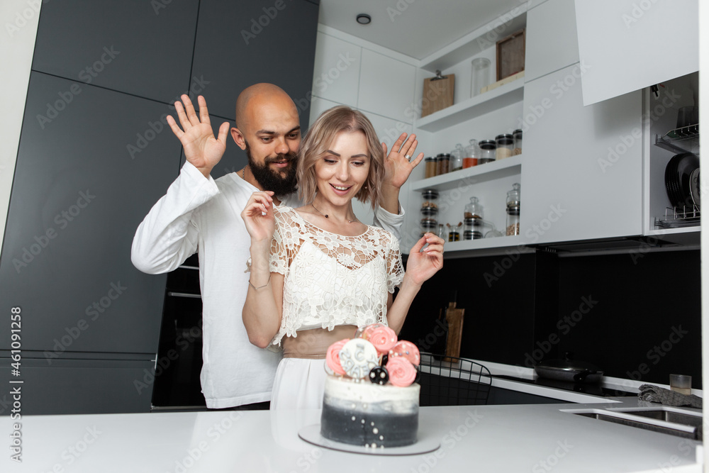 The husband makes a surprise to his wife in the kitchen, having closed ...